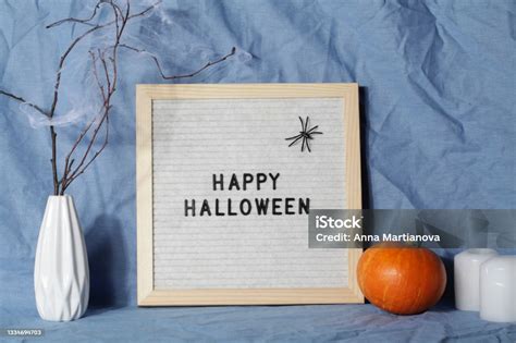 촛불 구겨진 파란색 섬유 소재에 호박을 곁들인 해피 할로윈이라는 문구가 있는 편지판을 느꼈습니다할로윈 데이 컴포지션파티 인사말