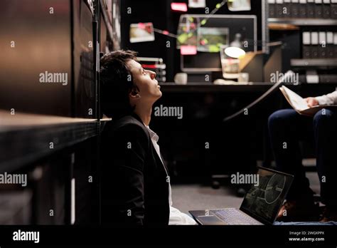 Tired Police Officers Working Overhours At Criminal Case Checking Victim Report In Arhive Room