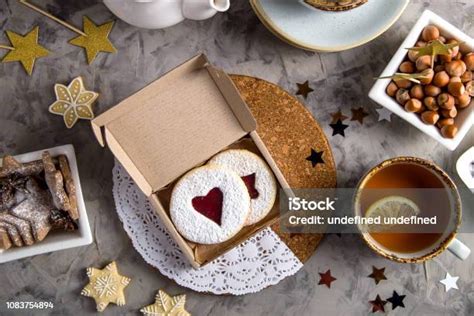 선물 상자 크리스마스 장식 양 초 및 회색 테이블에 녹차의 컵 사이에서 심장 모양의 잼 쿠키 라운드 수 제 베이킹 개념입니다 평면도 평면 위치 가루 설탕에 대한 스톡 사진