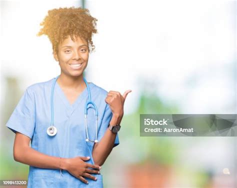 생기고 엄지 측면 가리키는 행복 한 얼굴로 웃 고 고립 된 배경 위에 젊은 아프리카계 미국인 의사 여자 가리키기에 대한 스톡 사진 및 기타 이미지 Istock