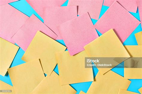 파란색 배경에 많은 노란색과 분홍색 사각형 빈 종이 스티커가 흩어져 있습니다 공간을 복사합니다 맨 위 보기 끈적거리는에 대한 스톡 사진 및 기타 이미지 Istock