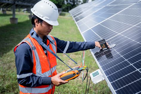 엔지니어들은 성능 검사기로 태양 전지판을 점검하여 각 태양 전지 패널이 최대 효율로 작동하는지 확인합니다 세계의 에너지를 보존하기위한 대체 에너지 재생 가능 사업 Test