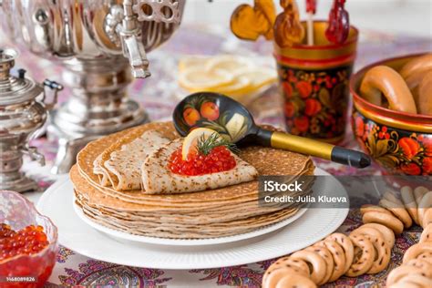 러시아 전통 러시아 휴일 마슬레니차 차 한잔 팬케이크 더미 빨간 캐 비어 레몬 베이글 막대 사탕 수탉 나무 숟가락 및 사모바르가있는 정물 0명에 대한 스톡 사진 및 기타