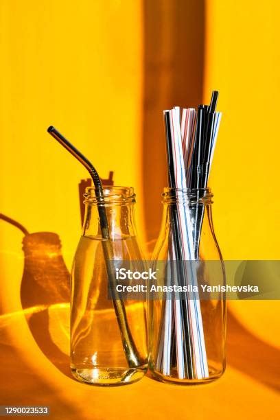 노란색 배경에 많은 여러 가지 빛깔의 플라스틱 빨대와 스테인레스 스틸 재사용 음주 빨대 제로 폐기물 개념 플라스틱이 없습니다