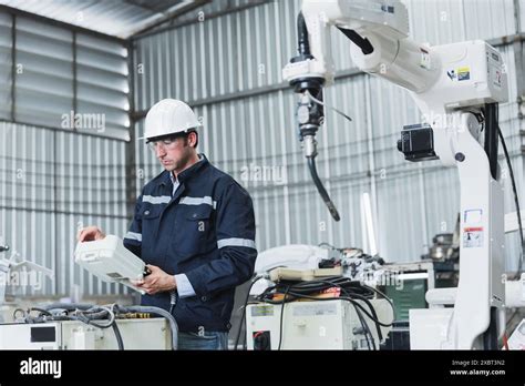 Engineer Controlling Robot Arm At Factory Checking The Operation Of Robot Arm Technology
