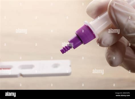 Doctor Dropping Buffer Solution Onto Disposable Express Test Cassette