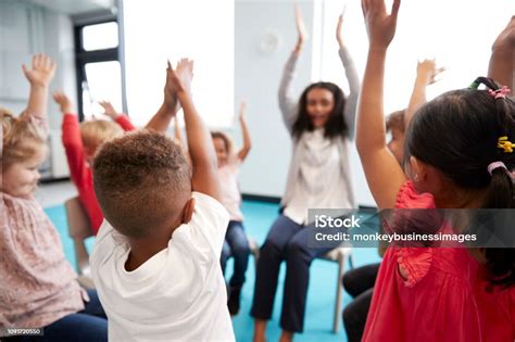 유아 학교 어린이 교실 원의 자에 앉아 그들의 여성 교사와 손을 높이의 클래스를 닫습니다 교사 교육 관련 직업에 대한 스톡 사진