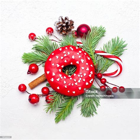 흰색 치장 벽토 석고 질감에 도넛 녹색 전나무 나뭇 가지 원뿔 Baubles 및 빨간 홀리 베리와 크리스마스 카드 구성 Xmas 카드 탑 뷰 플랫 레이 도넛에 대한 스톡