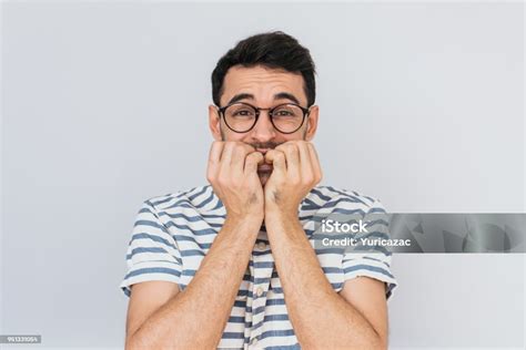 무서 워 하 고 불안 한 표정으로 젊은 백인 남자의 초상화 물린 손가락 손톱 줄무늬 셔츠 두려워 하 고를 착용 인간의 표정 고 부정적인 감정 개념입니다 무서움에 대한 스톡