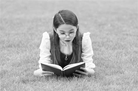 Surprised Girl Reading Book Lying On Grass Reading Teen Girl Reading