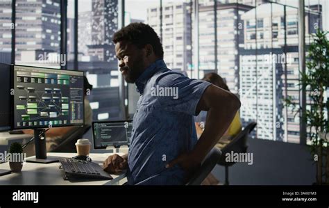 Employee With Grimace On Face Stretches To Relieve Muscle Strain While