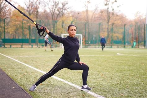 Premium Photo Girl Athlete Training Using Trx On Sportground Mixed