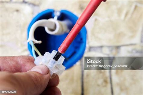 플라스틱 전기 커넥터 또는 단자대 전기 기술자는 벽면 소켓을 설치할 때 전선을 고정하는 장착 나사를 조입니다 0명에 대한 스톡 사진 및 기타 이미지 Istock
