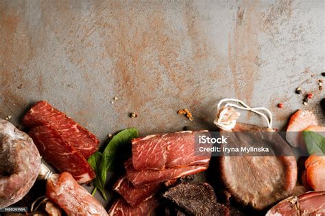 복사 공간이 있는 콘크리트 테이블 배경 위에 경화된 고기 간식 훈제 고기 조미료를 곁들인 마른 소시지샤퀴테리 플레이트 전통 공예