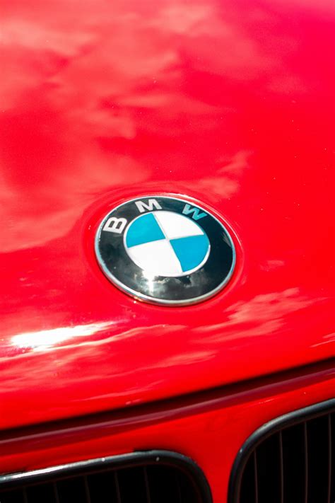 빨간 차에 Bmw 엠블럼을 클로즈업한 모습 사진 Unsplash의 무료 로고 이미지