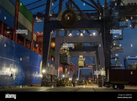 Operation Of Container Terminal At Night Unloading Container Ship At Night Mooring Cranes