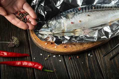 요리사는 부엌 테이블에서 맛있는 점심을 준비하기 전에 고등어 생선에 향기로운 향신료와 후추를 추가합니다 건강한 생활방식에 대한 스톡 사진 및 기타 이미지 Istock
