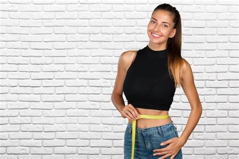 Premium Photo Athletic Slim Woman Measuring Her Waist By Measure Tape