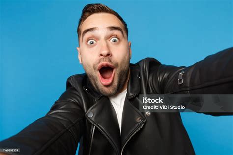 까만 가죽 자 켓 흰색 T셔츠 파란색 벽 배경 스튜디오 초상화에 고립 된 찾고 세련 된 젊은 얼굴을 가진 남자의 셀 카를 닫습니다 사람들은 진지한 감정 개념입니다 복사