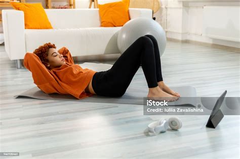 피트니스 운동 훈련 젊은 건강 적합 아프리카 소녀는 집에서 바닥에 요가 매트에서 자전거 크런치 복근 운동을 하고 있다 운동복을 입은 운동 여성은 복부를 펌핑하고 있습니다