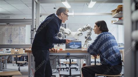 Engineers Discussing Robotic Arms In Research Laboratory Stock Image