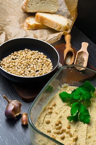 후 머 스 또는 Houmous 전채 만든 으깬된 Chickpeas의 Tahini 레몬 마늘 올리브 기름 파 슬 리 커 민 및 삼목 너트 나무 테이블 0명에 대한 스톡 사진