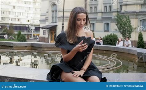 Slow Motion Footage Of Young Woman In Short Dress Sitting In Park At