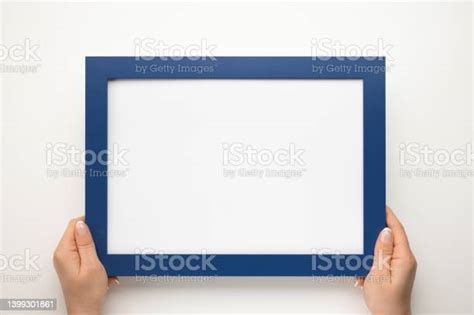 프레임 모형을 잡기 사진 모형 여자 손은 파란색 프레임을 잡고 있습니다 프레임과 포스터 디자인용 프레임 크기 A4 손에 복사