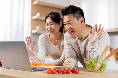 Premium Photo Happy Asian Couple Having Video Chat While Cooking At