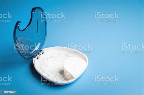 교정 치료 3d 프린터에 인쇄 된 새로운 보이지 않는 플라스틱 교정 장치는 사람이없는 파란색 배경에 특별한 흰색 상자에 있습니다 치아 교정장치에 대한 스톡 사진 및 기타