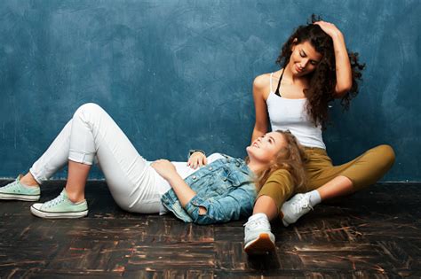 젊은 예쁜 십대 소녀 친구 금발과 갈색 머리 곱슬 머리 포즈 명랑 한 에 블루 배경 라이프 스타일 사람들 개념 2명에 대한 스톡 사진 및 기타 이미지 Istock