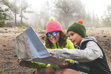 Premium Photo Woman With Son Reading Map At Forest