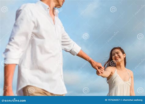 Pareja Joven Cogiendo De La Mano Y Corriendo Por La Playa Imagen De