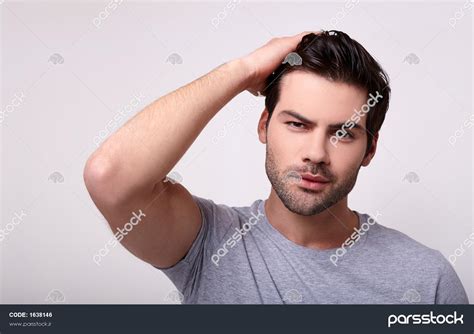 یک پسر جوان با ابهت با موهای کم تراشیده تیره و چشمان تیره با تی شرت