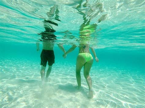 Premium Photo Low Section Of Couple Holding Hands While Swimming