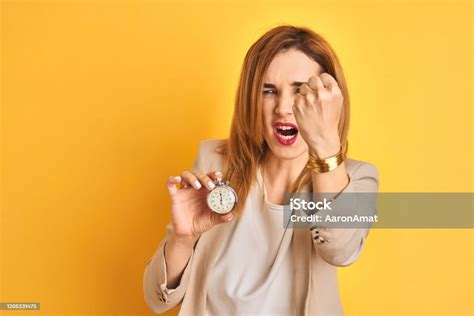 빨간 머리 백인 여성 노란색 고립 된 배경 에 스톱워치를 들고 짜증과 분노와 좌절 외침 미친 고함 으로 제기 된 손 분노 개념 분노에 대한 스톡 사진 및 기타 이미지