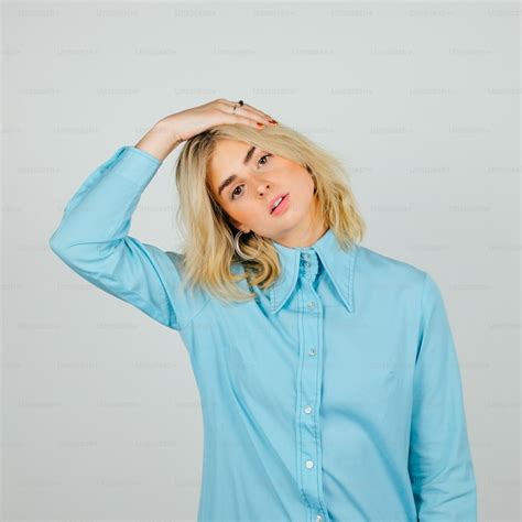 파란 셔츠를 입은 여자가 사진을 찍기 위해 포즈를 취하고 있다 사진 Unsplash의 소녀 이미지