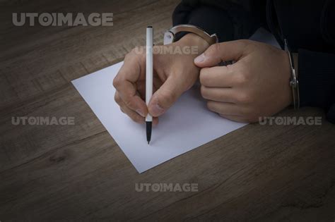 유토이미지 범죄와 법률 진술서를 작성하는 수갑을 찬 범죄자의 손