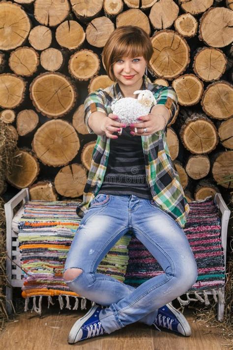 La Jeune Fille Aux Cheveux Courts Mignonne S Assied Et Tenant L Agneau De Jouet Sur Un Banc
