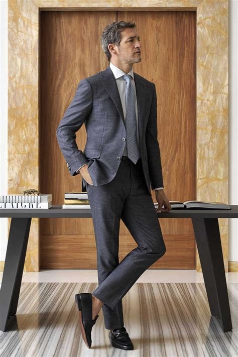 Man Wearing A Charcoal Suit White Shirt Light Blue Tie And Black