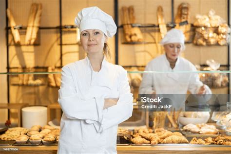 흰 코트와 요리사 모자를 쓴 여성 제빵사가 신선한 빵과 빵을 사도록 초대합니다 오븐 구이에 대한 스톡 사진 및 기타 이미지 오븐 구이 30 39세 35 39세