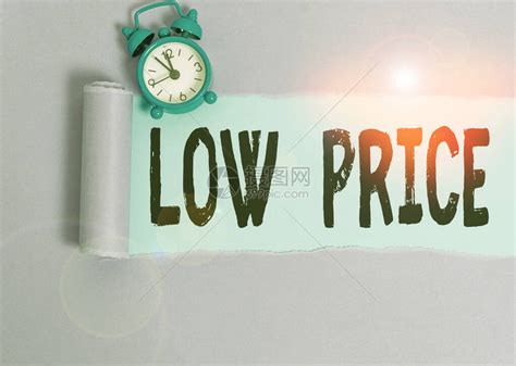 显示低价的文字标志展示价格的商业照片相对于其他同类物品而言是最低的闹钟和撕碎的纸板放在普通柔和的桌子背景上高清图片下载 正版图片504203726 摄图网