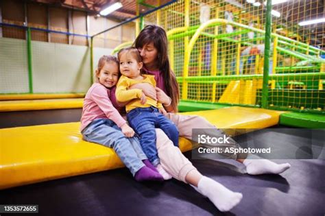 두 딸과 함께 실내 놀이 센터에서 트램폴린에 앉아 있는 어머니 18 23 개월에 대한 스톡 사진 및 기타 이미지 18 23 개월 2 3 살 30 34세 Istock