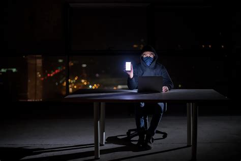 hacker using laptop computer while working in dark office 12443677