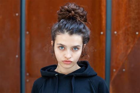 White Brunette Teenage Girl With Curly Hair Poses On The Street In The