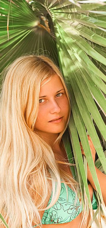 Blond Woman In Bikini Poses By Palm Tree On Beach Photo Background And