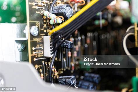 검은색 전자 회로 기판에 검은색 전선 몇 개와 노란색 와이어 하나를 연결하거나 일부 저항기 및 커패시터 구성 요소가 열린 장치에 납땜된 상태로 인쇄하는 P 커넥터의