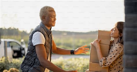 집 입구에서 백인 여성에게 소포를 주는 배달원 골판지 상자를 복용하는 어린 웃는 소녀 운송 및 물류의 개념 배달 서비스의 아이디어 사진 Unsplash의 표현하다 이미지