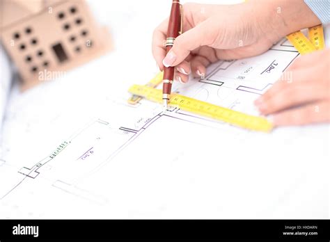Blueprint Of Office Building Over Blurred Adult Male Engineer Examining Documents Stock Photo