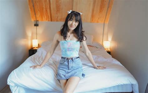 Asian Woman Wearing A Dress Sitting On The Bed Stock Image Image Of